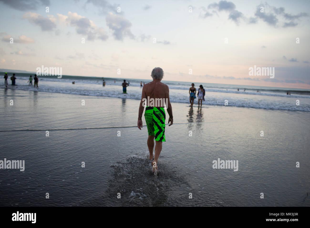 Tourists enjoy the sea at dusk on Bali's Kuta beach Stock Photo - Alamy