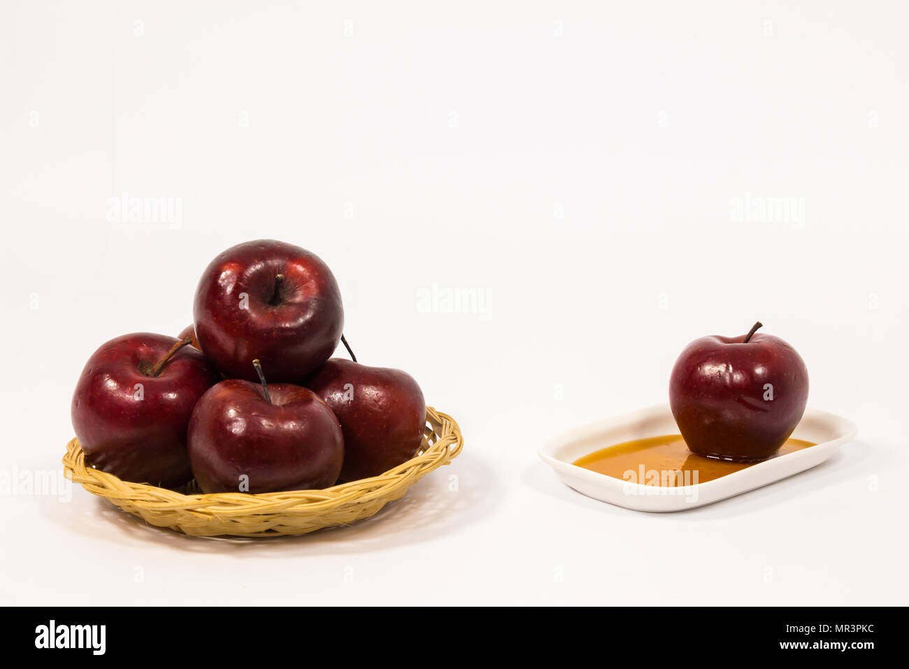 Pile of red apples and red apple on white plate with honey isolated on ...
