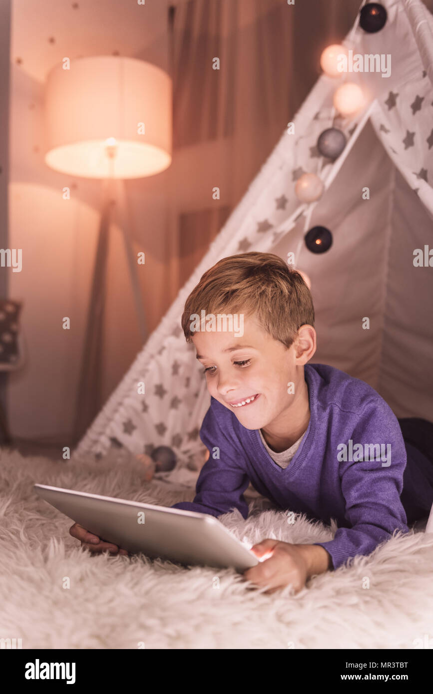 Smart positive boy looking at the tablet screen Stock Photo - Alamy