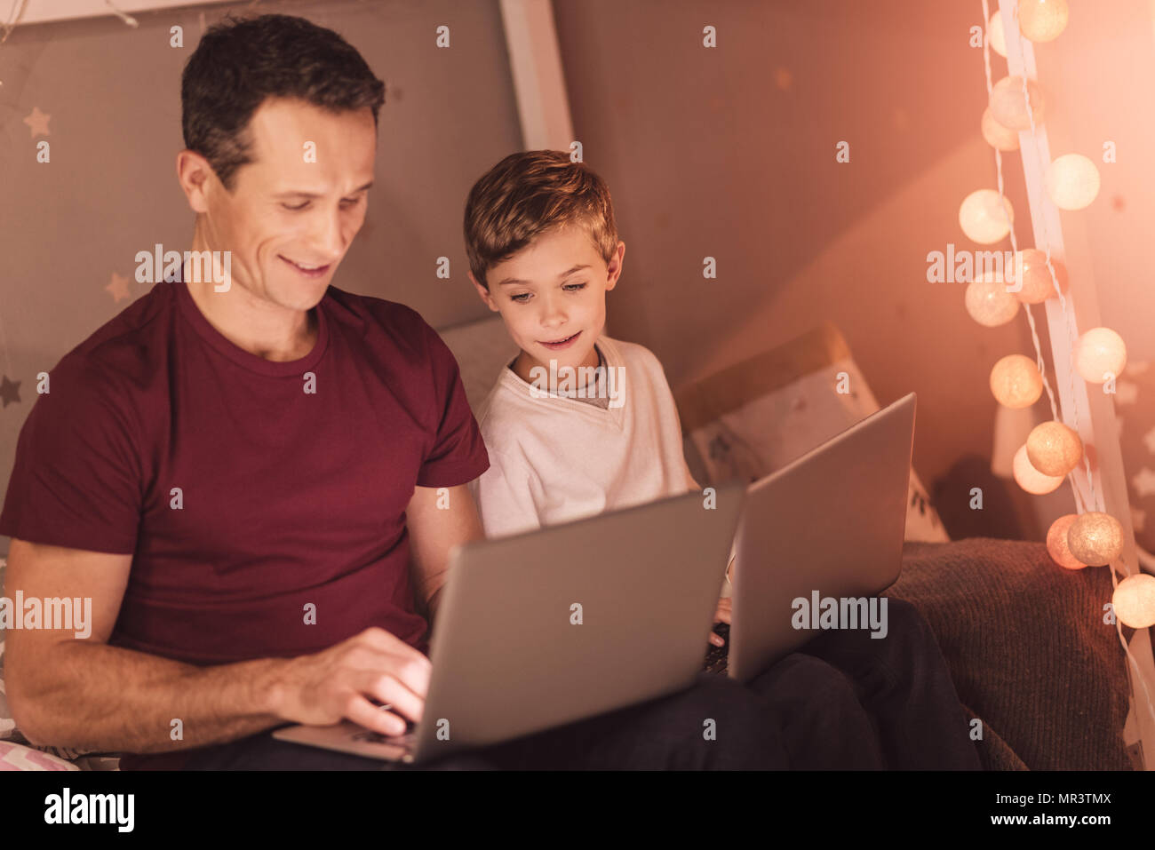 Joyful positive father and son using their laptops Stock Photo - Alamy