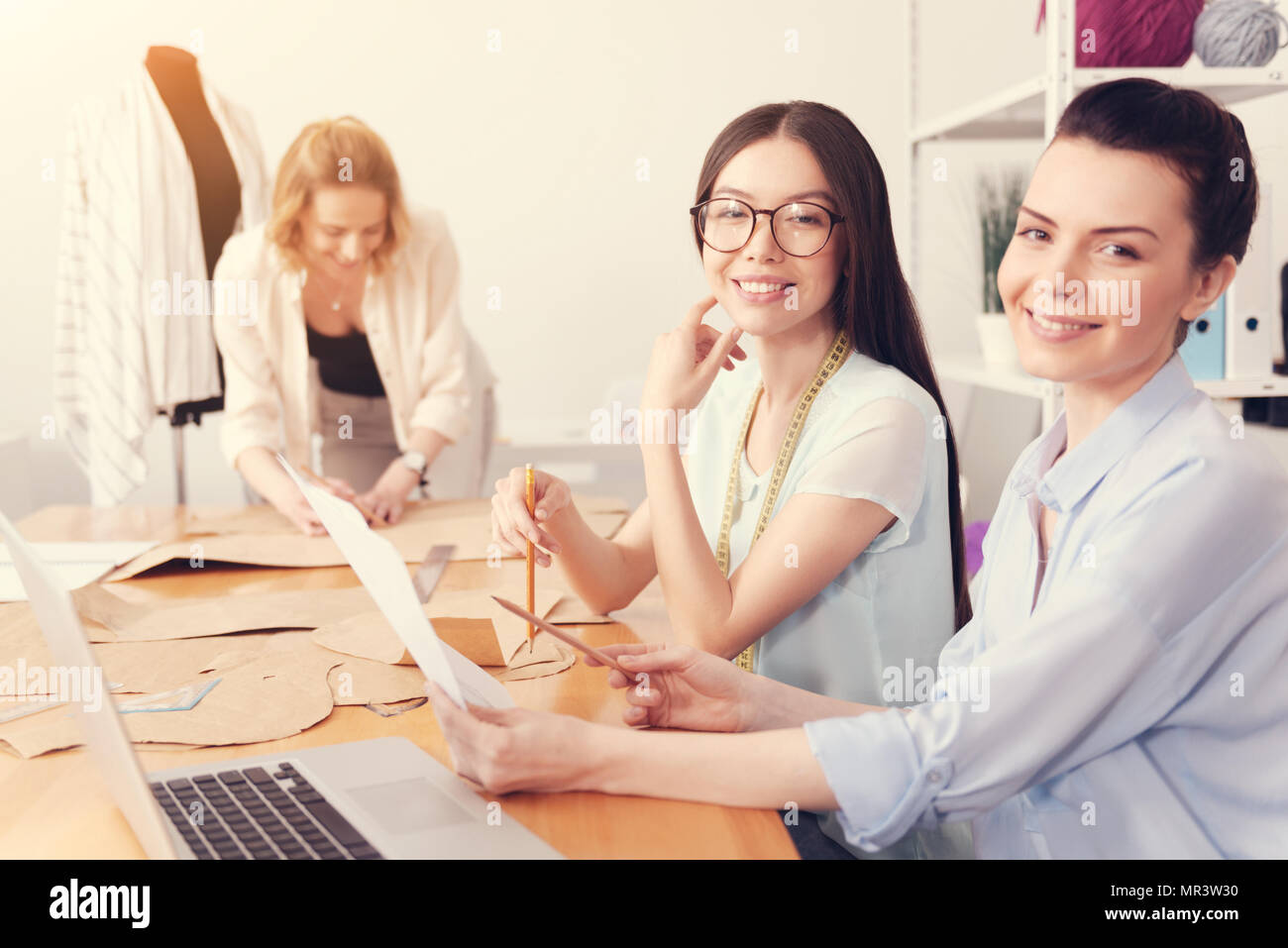 Positive designers working in the table Stock Photo - Alamy