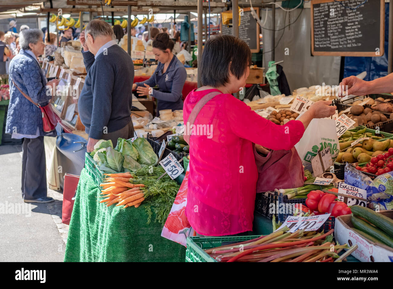 Asian woman seen paying for fresh produce at an open air market in an ...