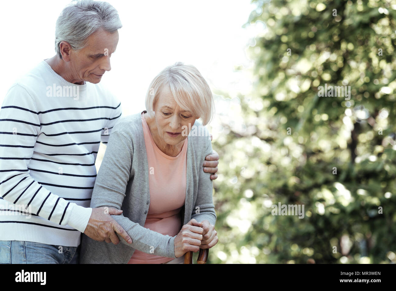 Upset female person leaning on walking stick Stock Photo - Alamy