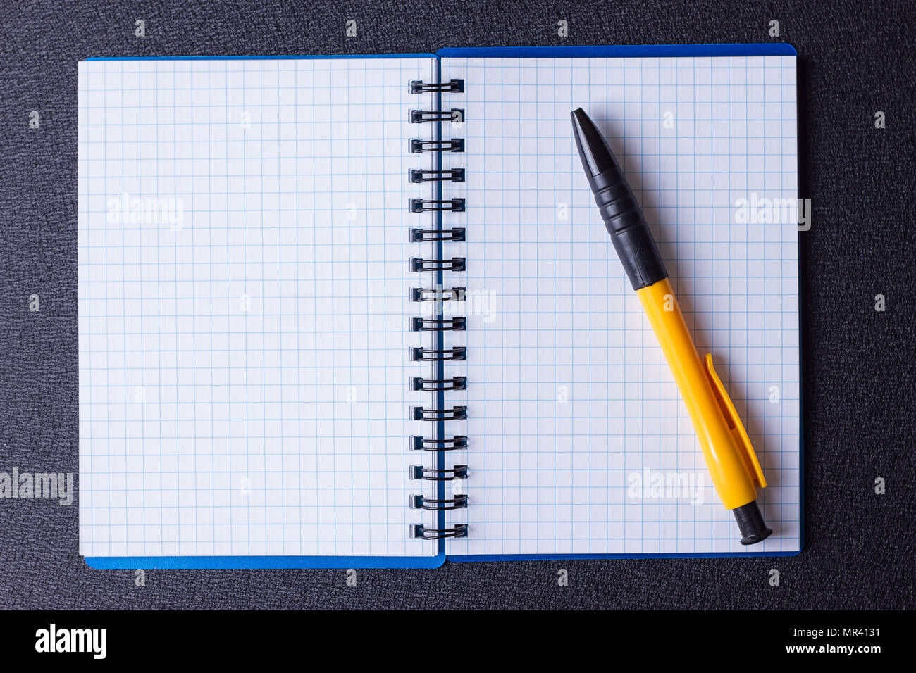 Open notepad on a spiral and pen on a black background Stock Photo - Alamy
