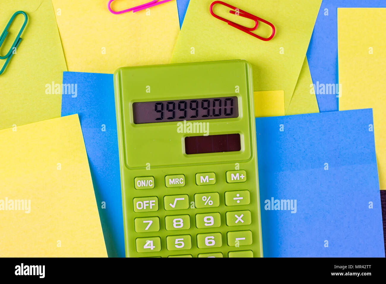 Multi colored pasted stickers and green calculator Stock Photo - Alamy