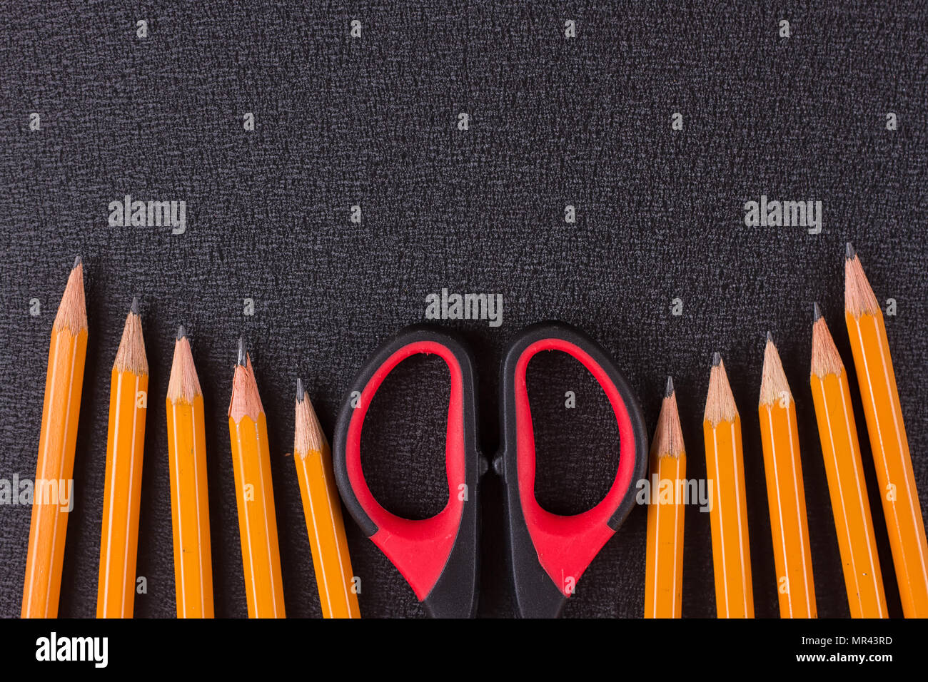 Simple pencils and scissors on a black background Stock Photo - Alamy