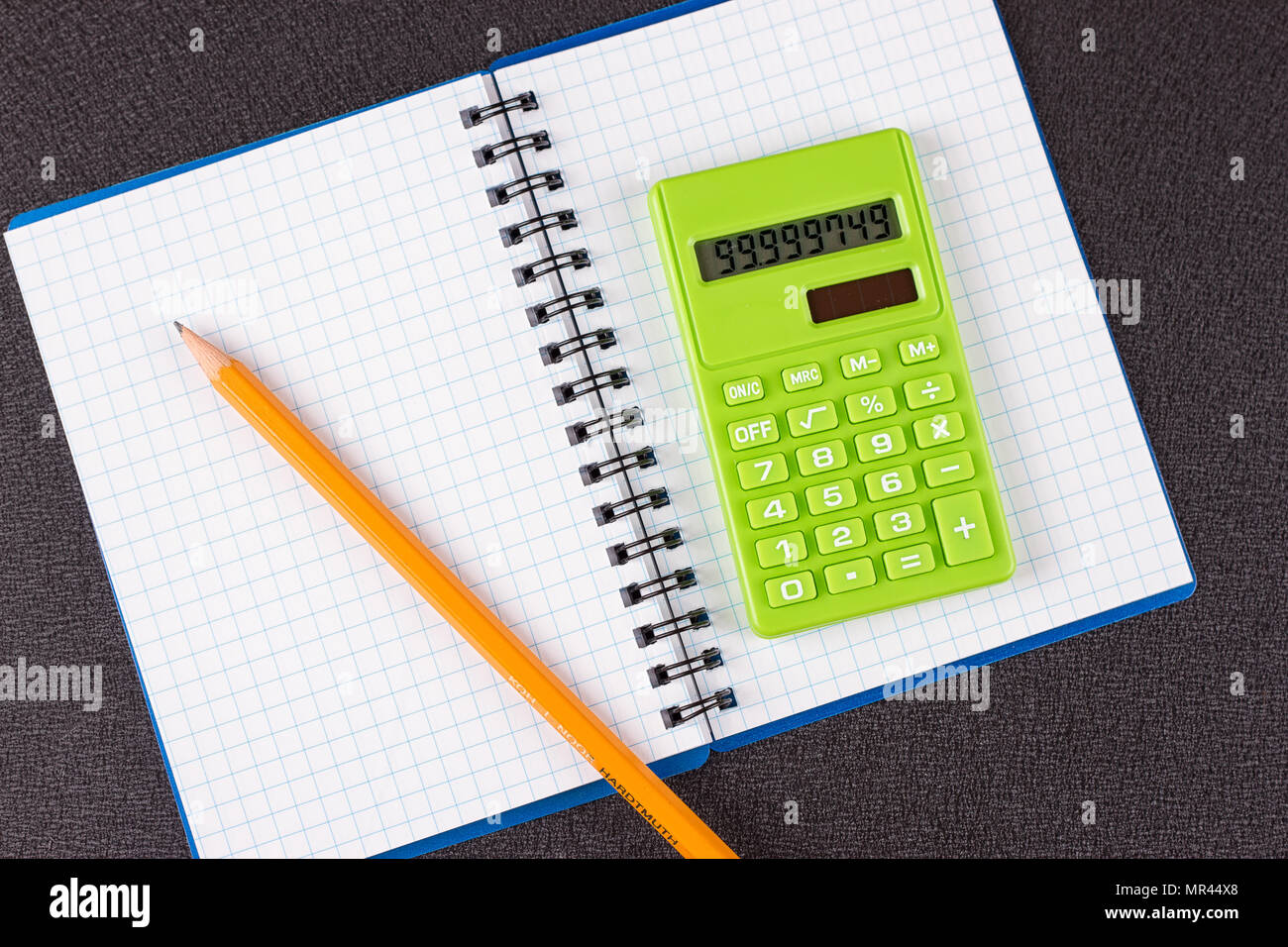 Calculator and pencil on notepad on the black background Stock Photo ...
