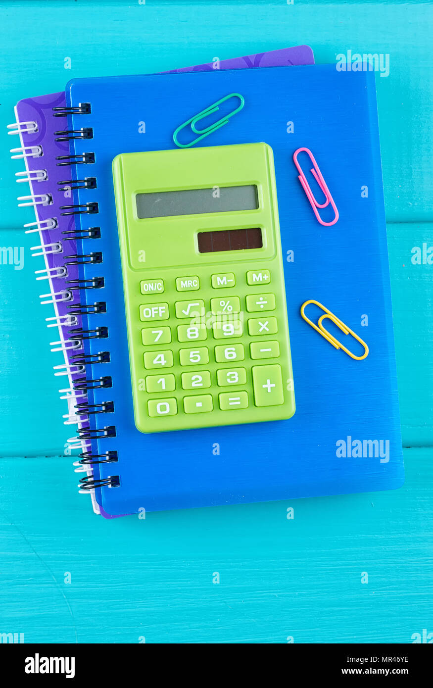 Notepad, calculator and other stationery tools on wooden table. Top ...