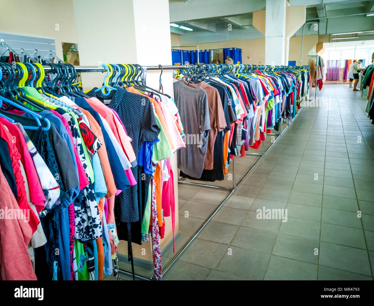 many different clothes hanging on hangers in the store Stock Photo - Alamy