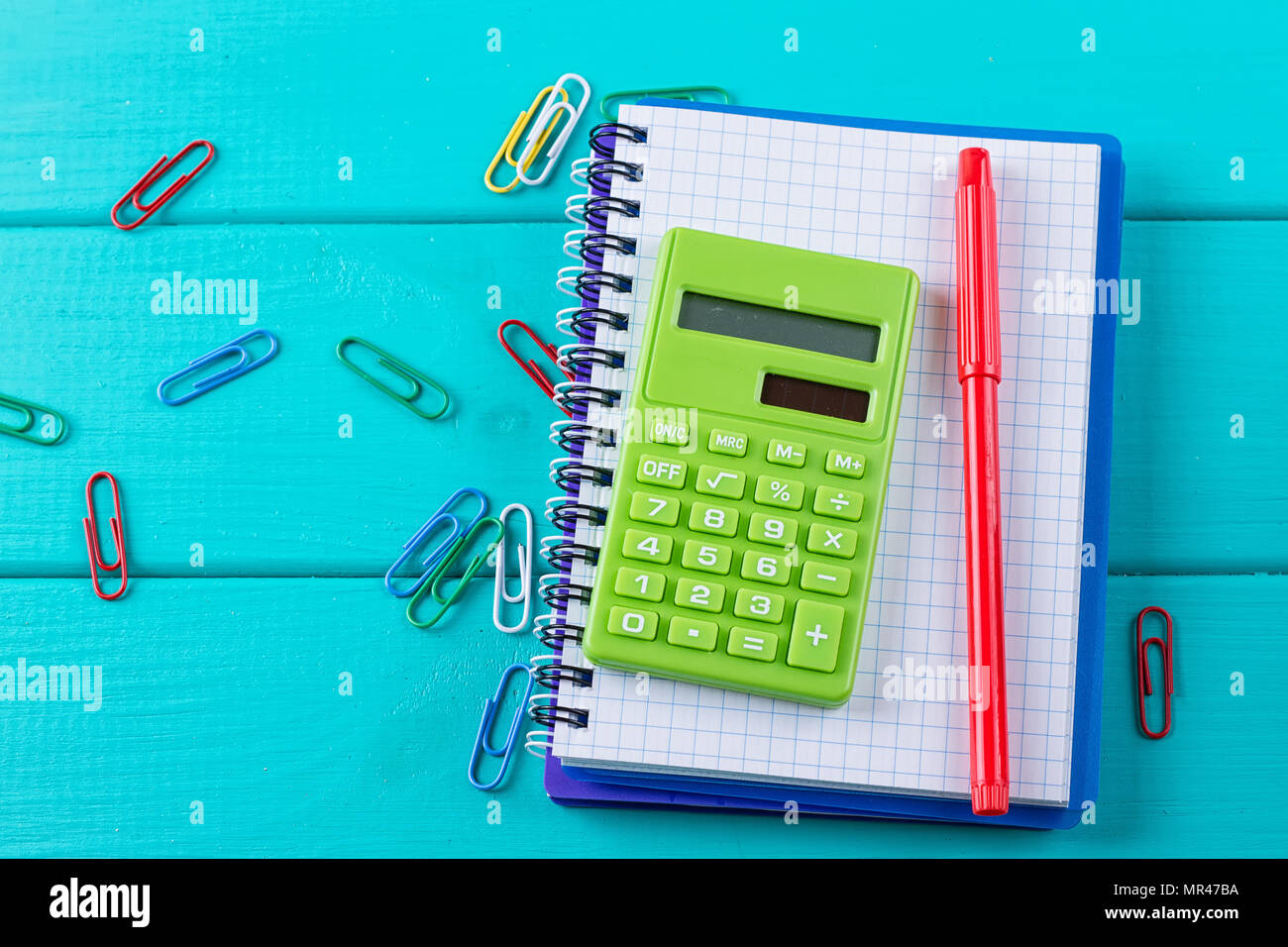 Calculator and pencil on notepad on the blue background Stock Photo - Alamy