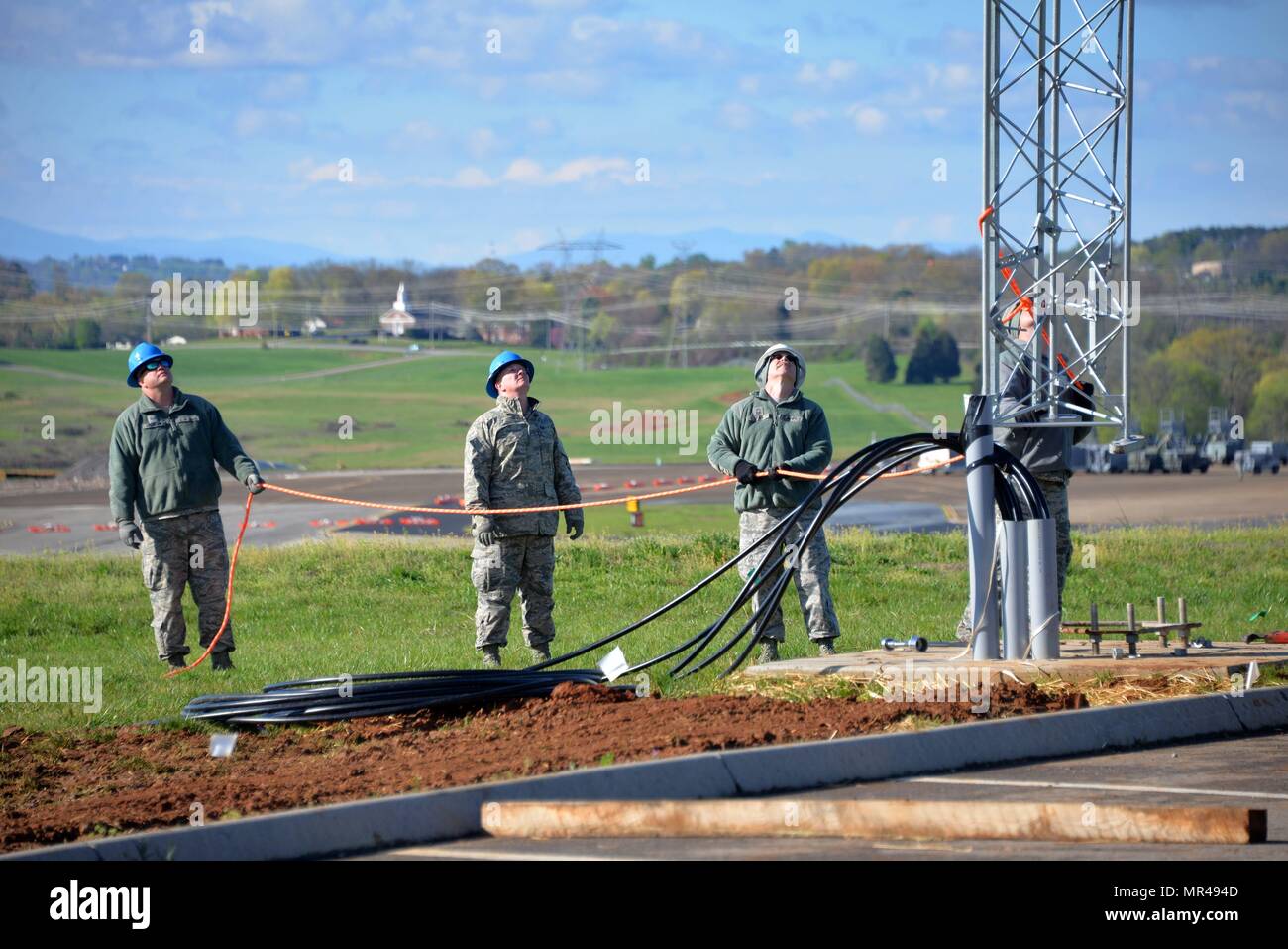Members of the 241st Engineer Installation Squadron help to erect a ...