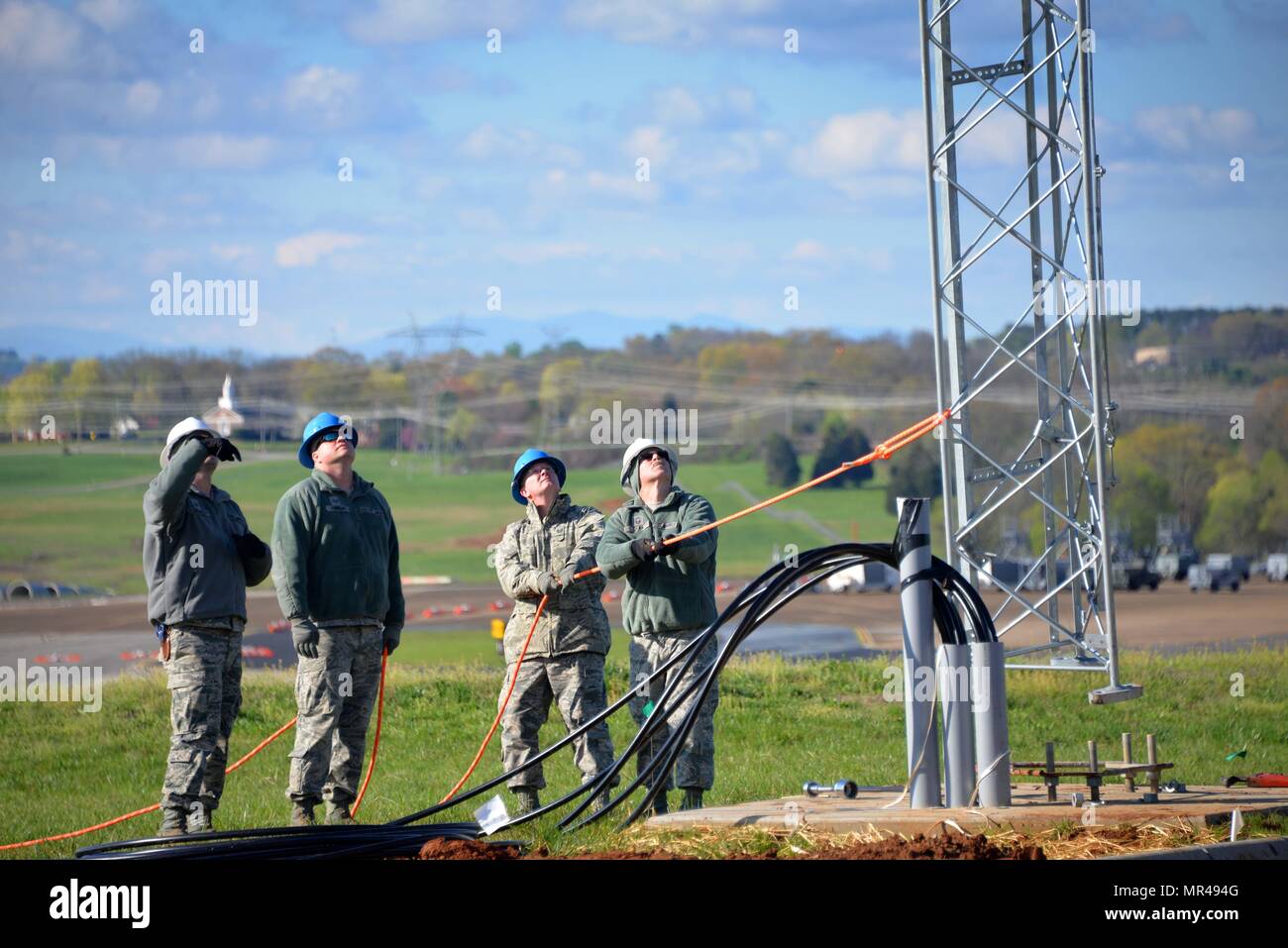 Members of the 241st Engineer Installation Squadron help to erect a ...