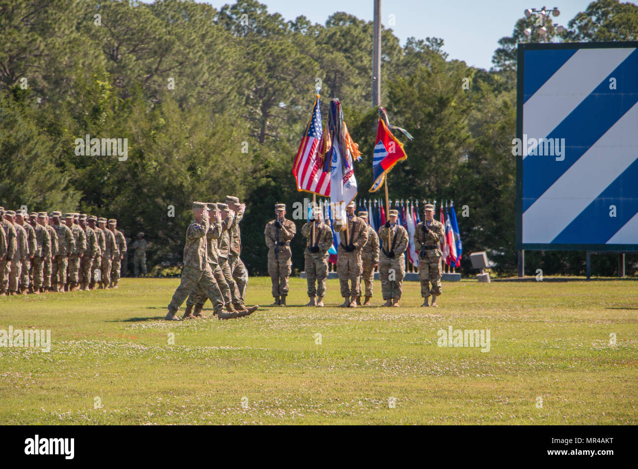 The reviewing party salutes the color guard while inspecting the troops ...