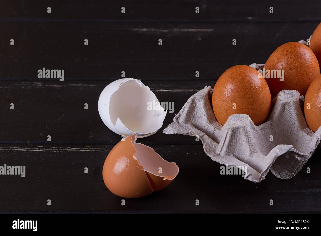 Cardboard egg box And eggshell shells on black wooden background. Eggs ...