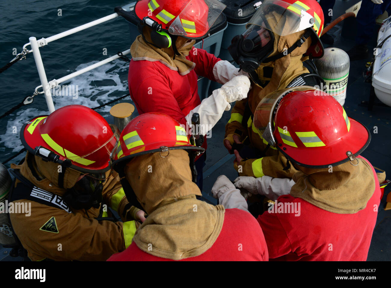 Crewmembers aboard the Coast Guard Cutter Swordfish assist each other ...