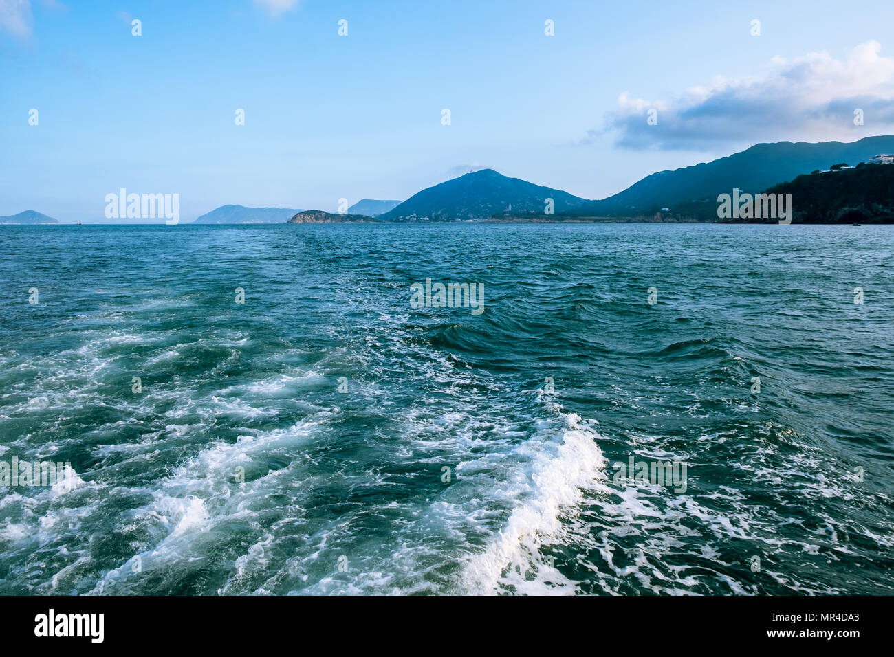 Wave trace with white foam on sea water surface behind of fast moving ...