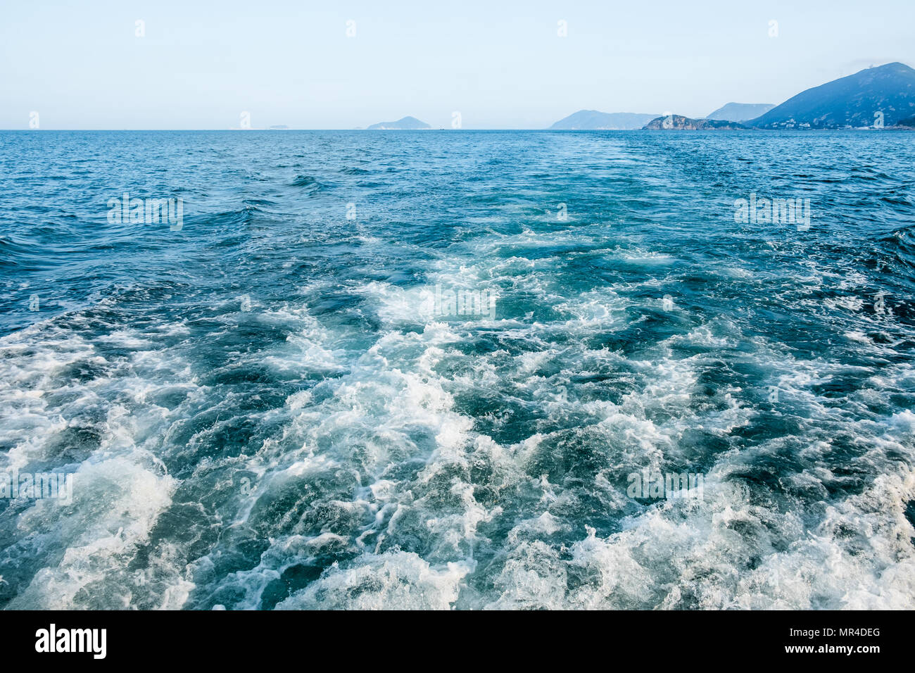 Wave trace with white foam on sea water surface behind of fast moving ...