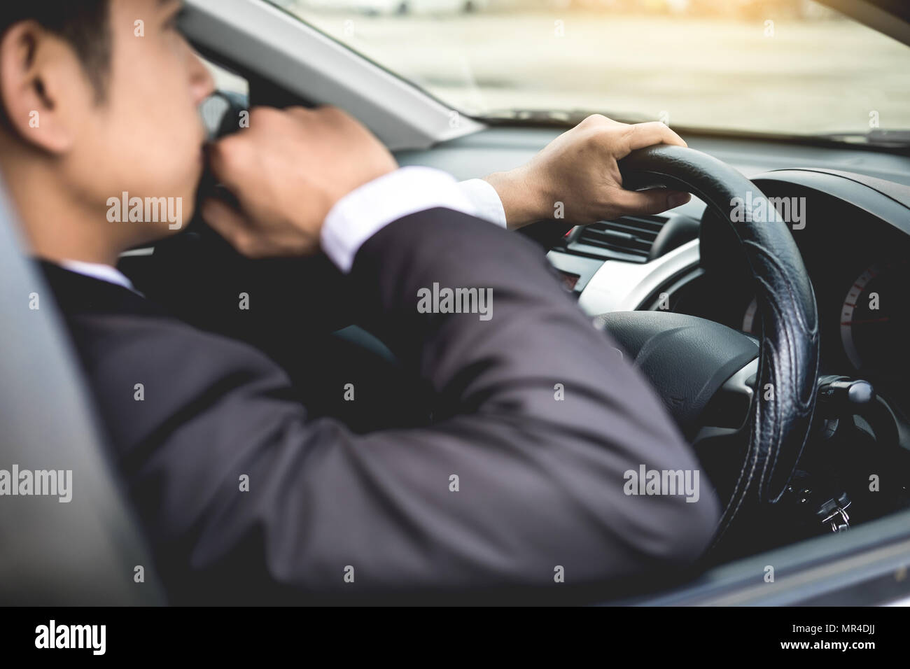 Portrait of a young handsome businessman driving a luxury sports car ...