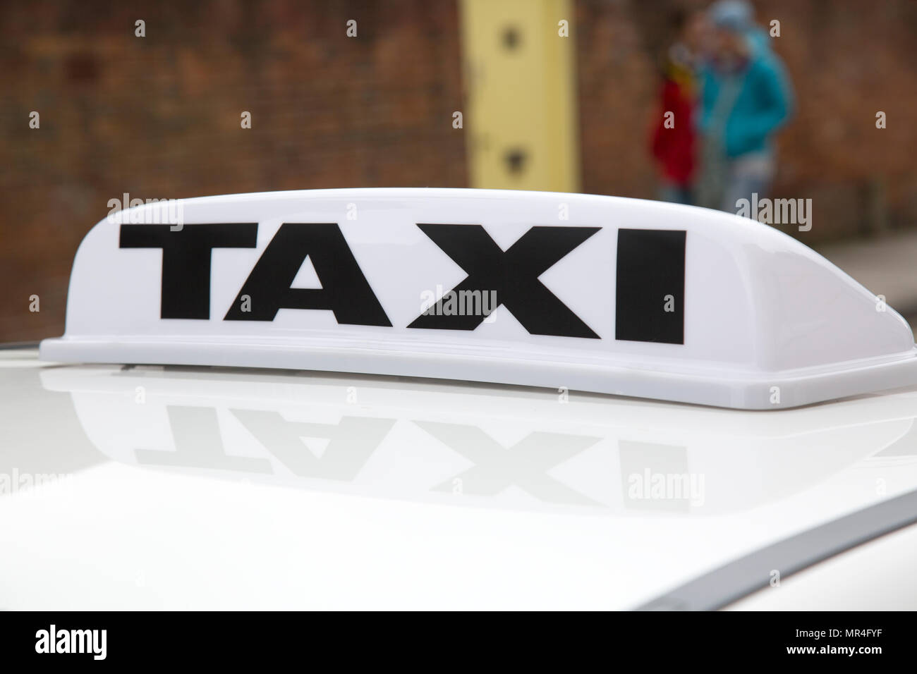 White Taxi Sign in Urban Setting Stock Photo - Alamy