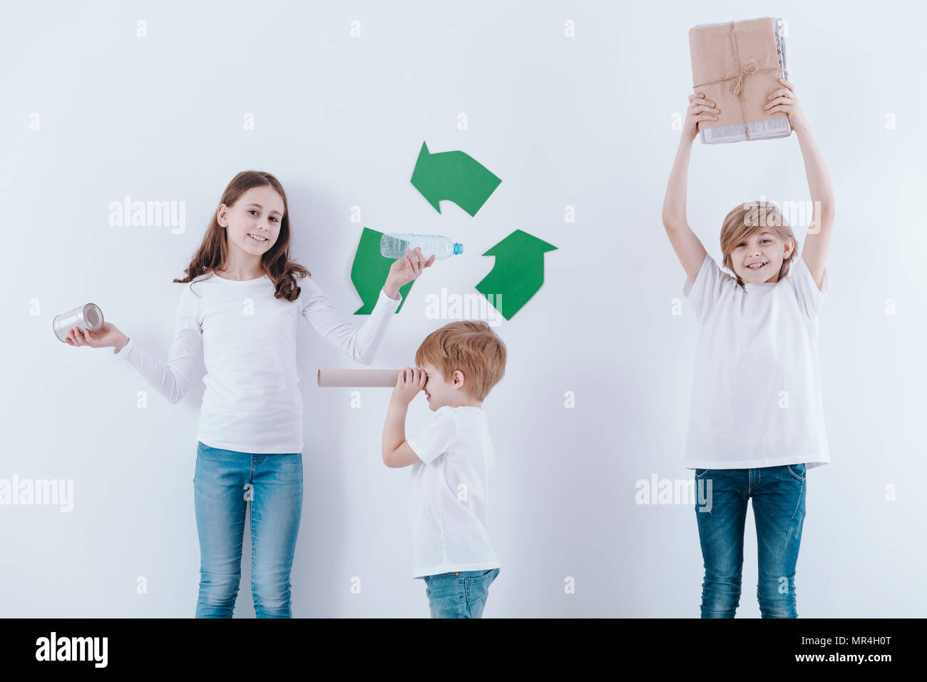 Kids playing with paper, metal and plastic waste, promoting recycling ...