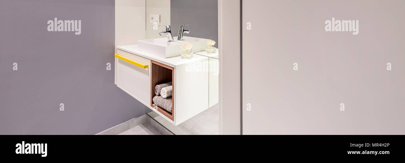 Side view of modern washbasin with a cabinet and towels next to an ...