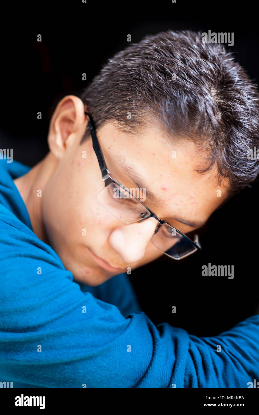 Portrait of a young teenager posing with a small smile on his face in a ...