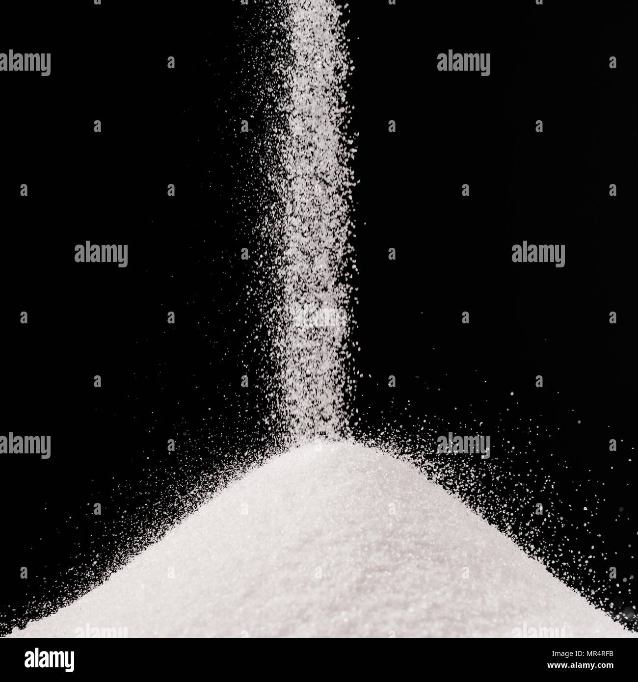 sugar falling on pile isolated on black Stock Photo - Alamy