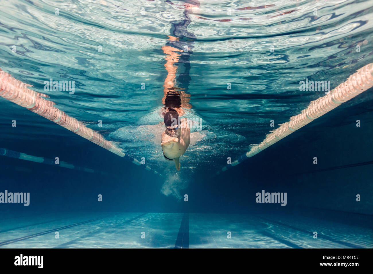 underwater picture of young swimmer in cap and goggles training in ...