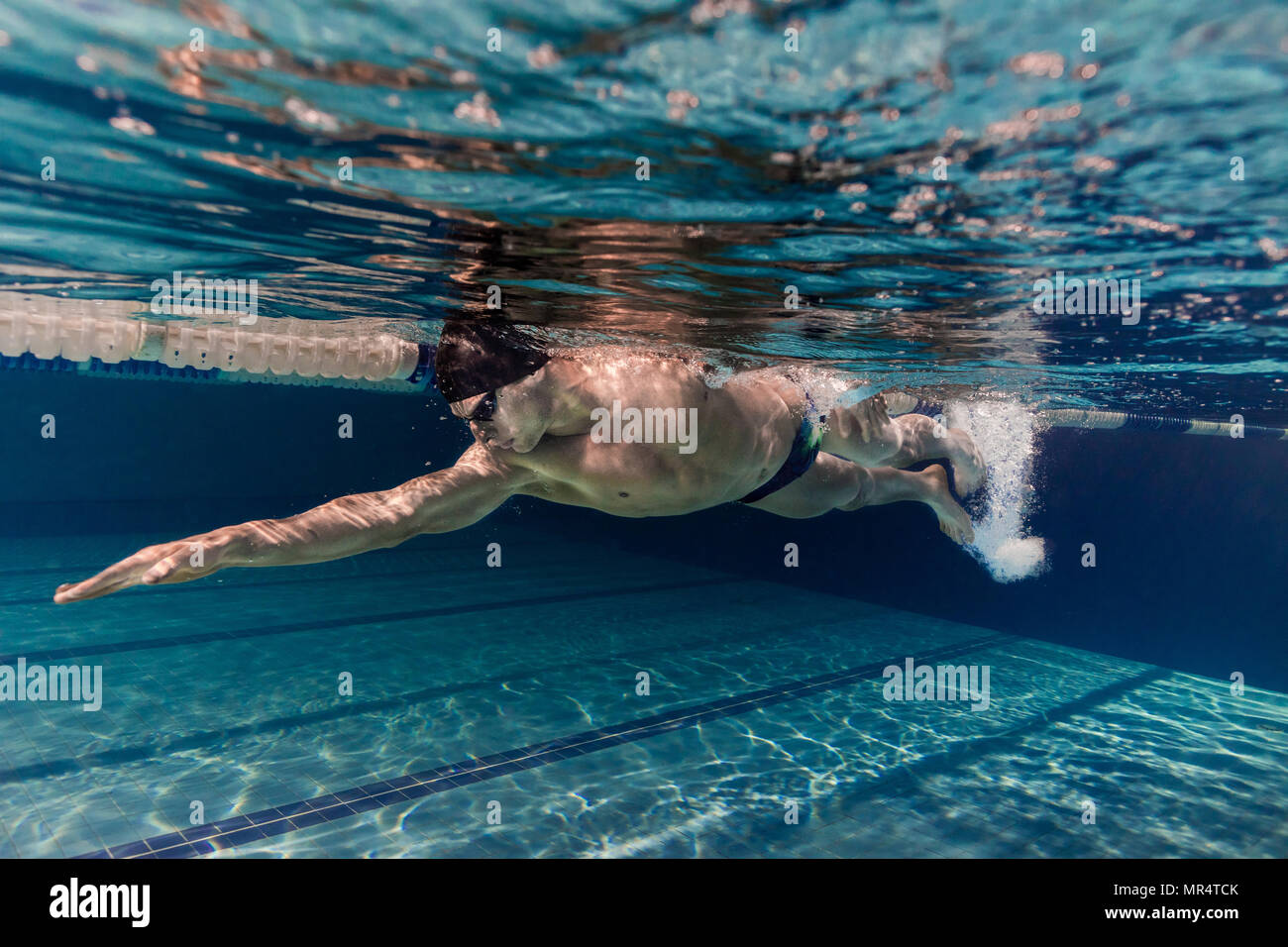 underwater picture of young swimmer in cap and goggles training in ...