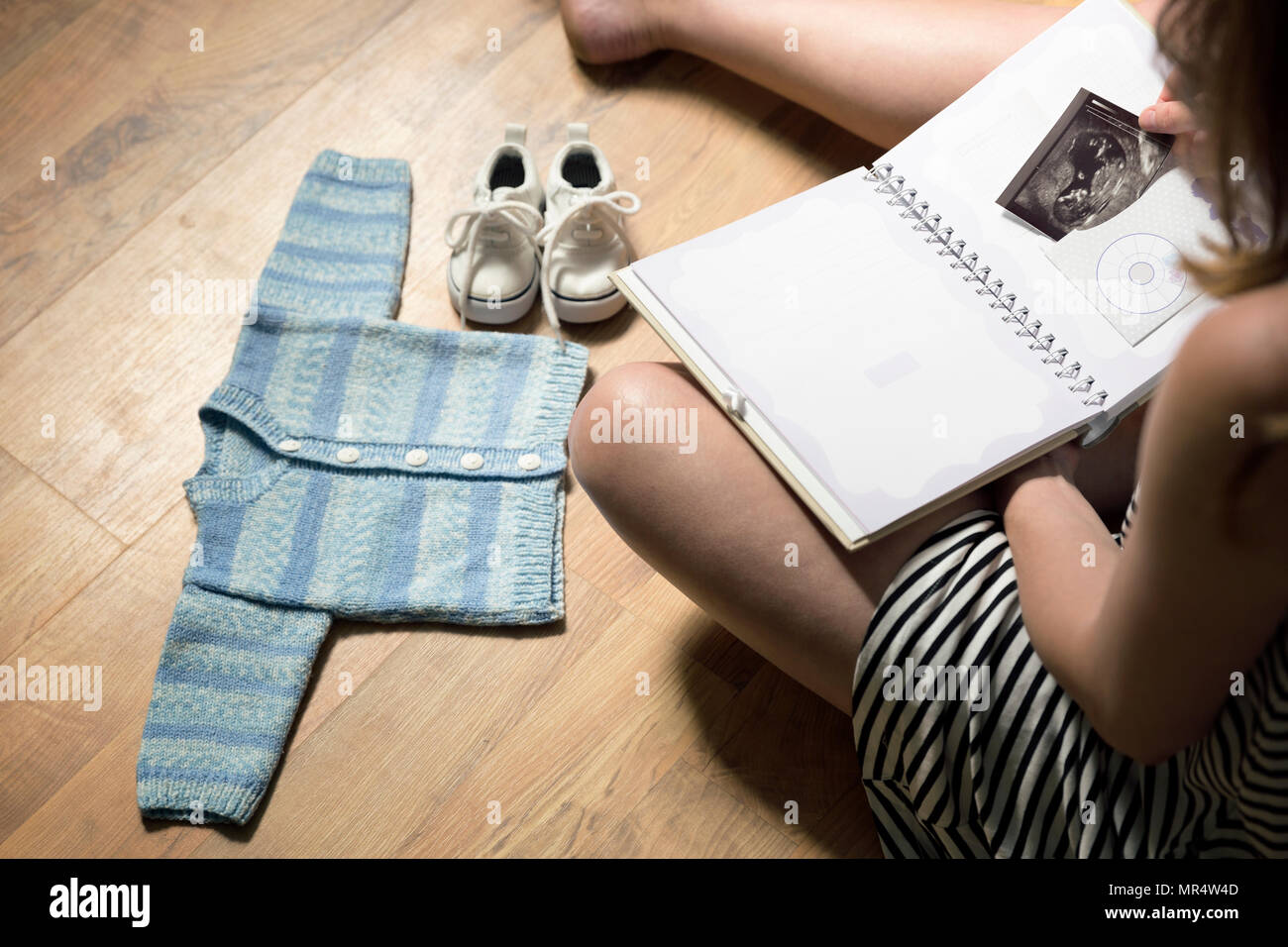 woman-placing-baby-s-sonogram-into-baby-s-first-year-memory-book-baby