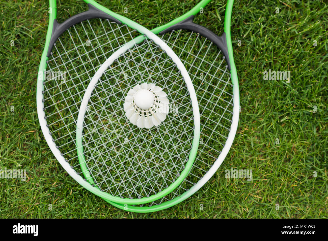 top view of shuttlecock on badminton rackets lying on green grass Stock ...
