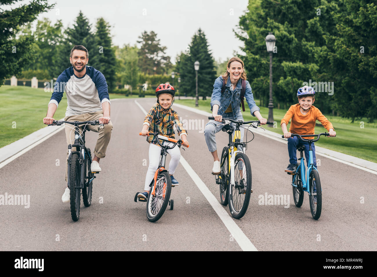 big happy family riding bicycles together in park Stock Photo - Alamy