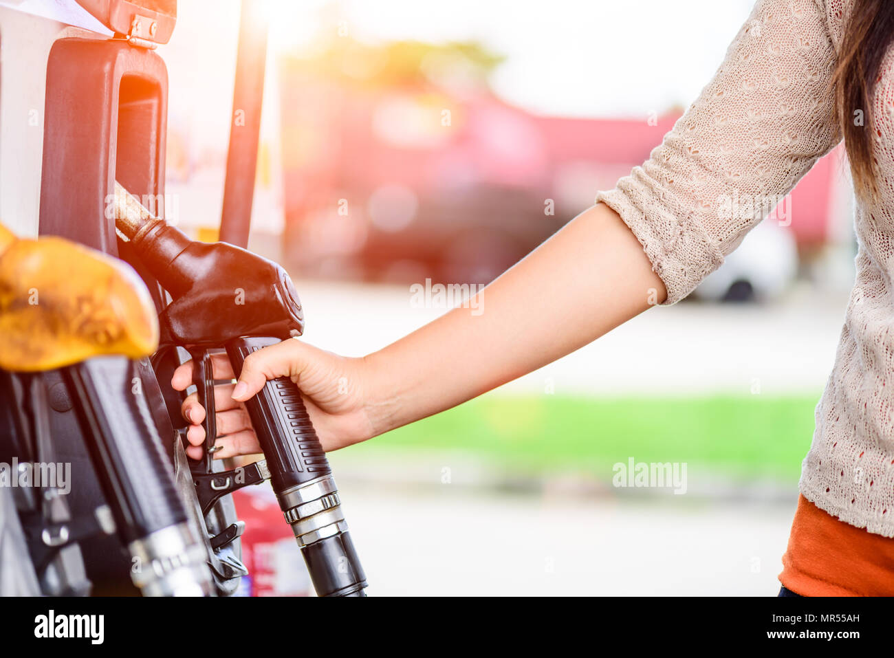 Closeup of woman hand holding a fuel pump at a station Stock Photo - Alamy