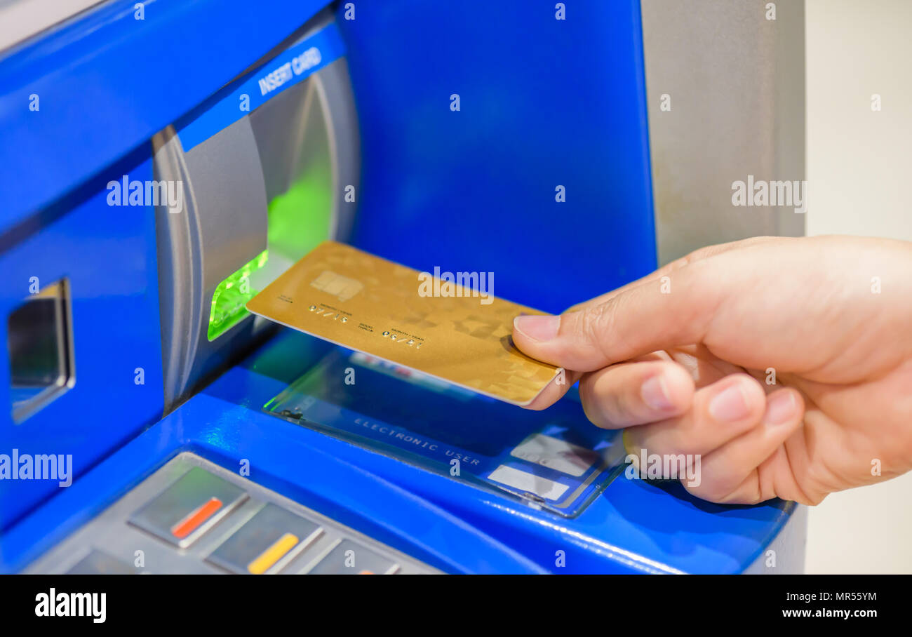 Closeup woman hand inserting debit card into an ATM machine Stock Photo ...