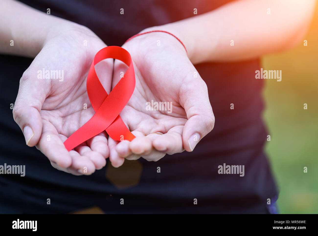 Woman hands holding red AIDS awareness ribbon. World Aids Awareness ...