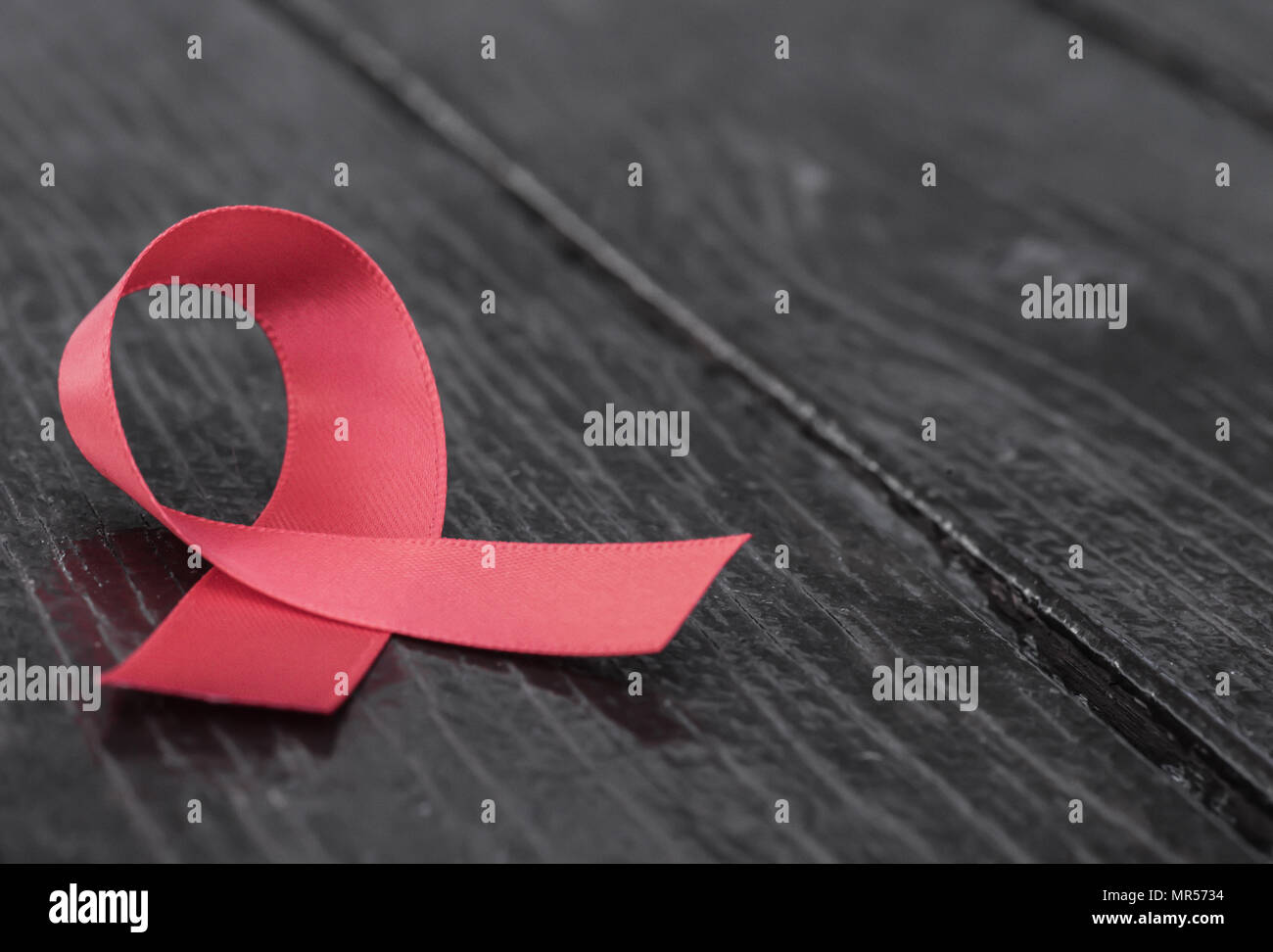 Red AIDS awareness ribbon on wooden background. Aids and HIV Awareness ...