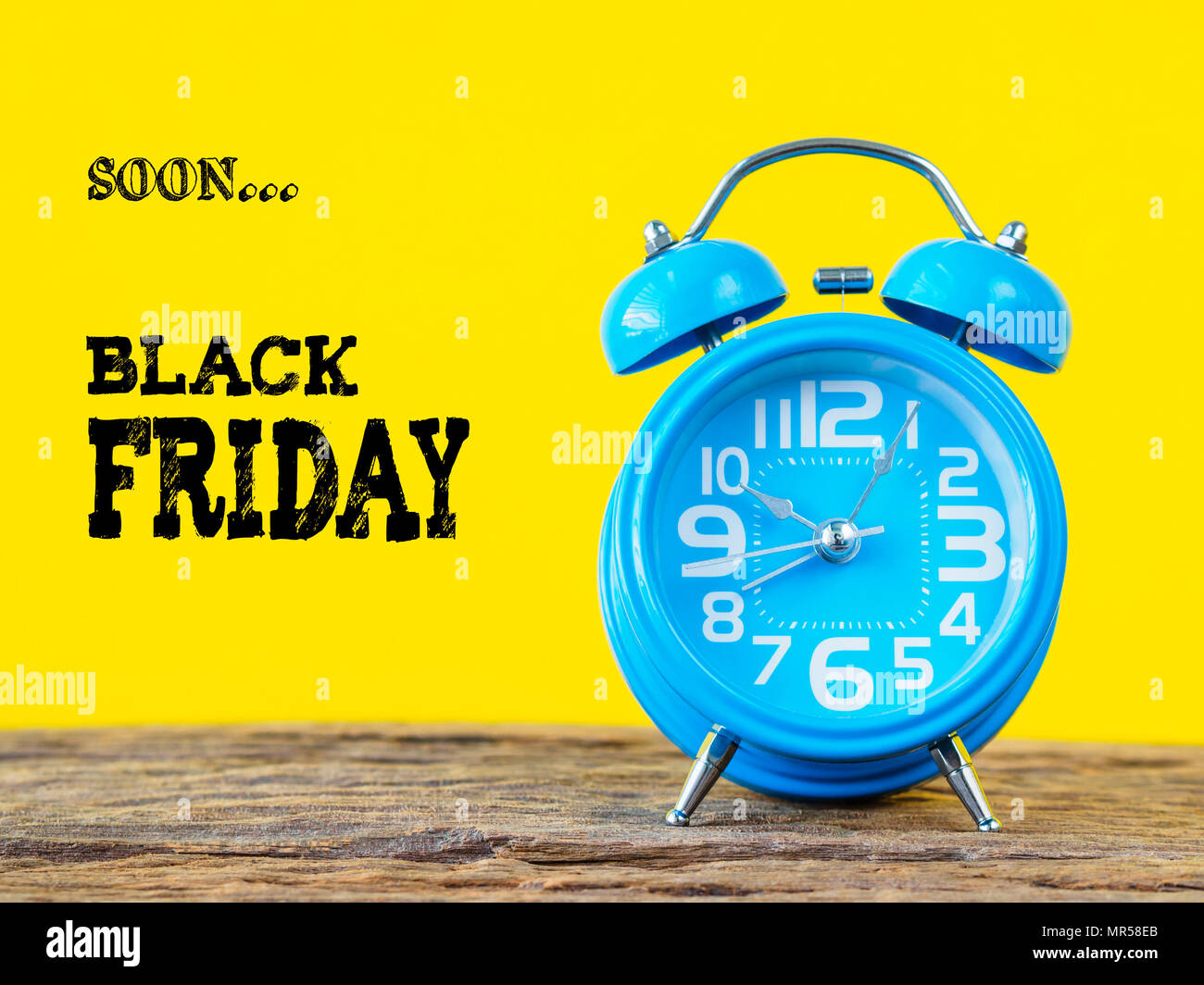 Black Friday time sale concept, blue alarm clock with yellow background ...