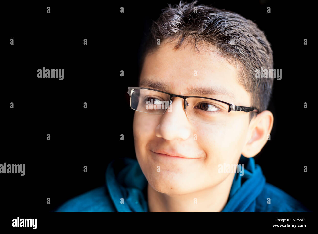 Portrait of young teenager boy wearing half rim black colored reading ...