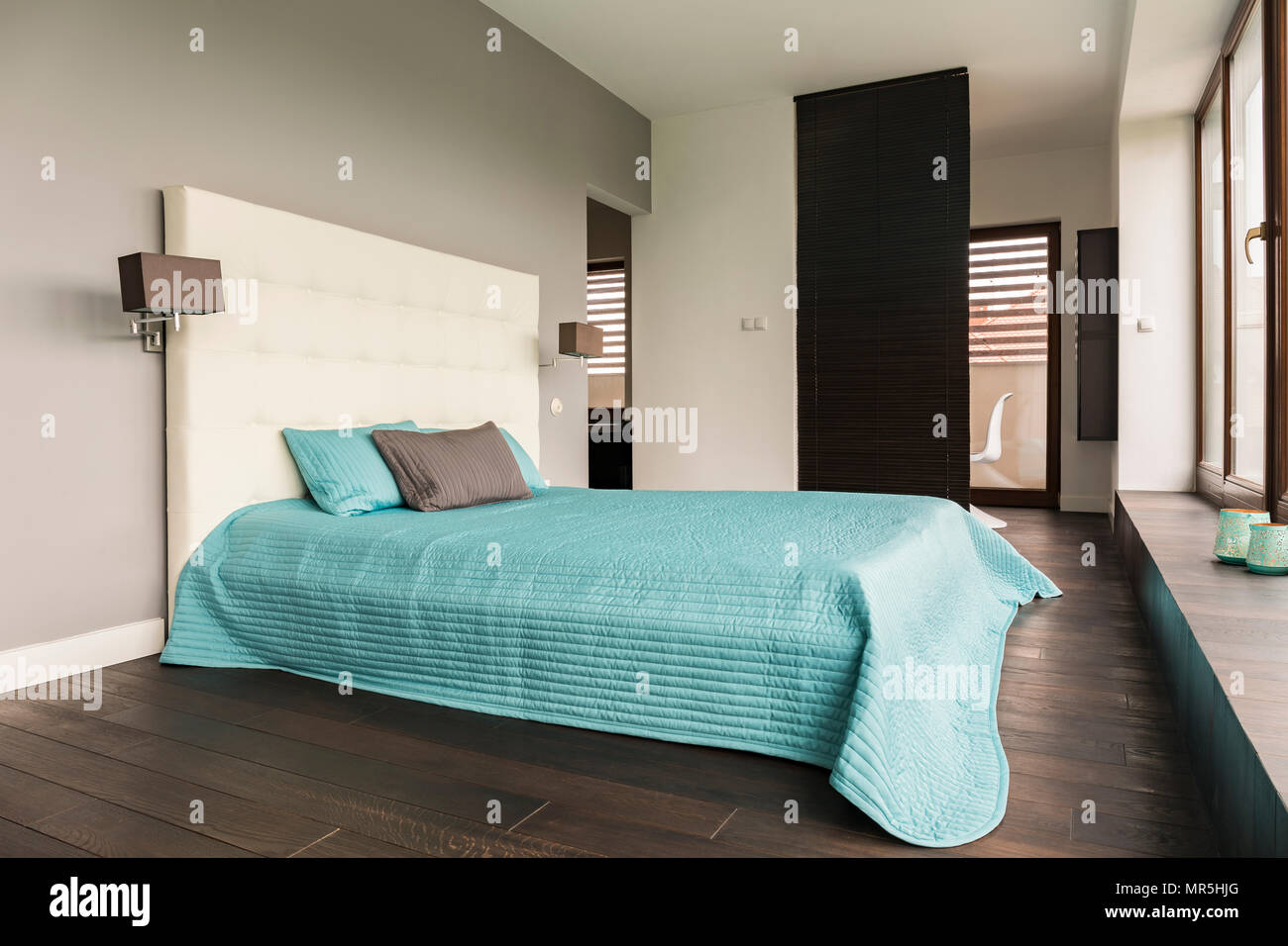 Grey bedroom with upholstered large bed and ice blue bedding Stock ...