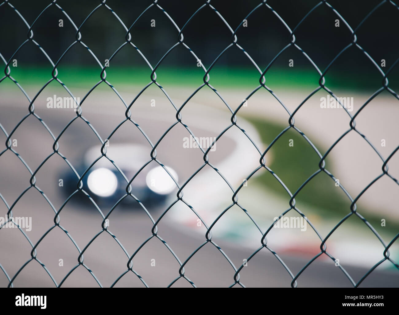 view of blurred racing car from a metal grid - sport background Stock ...