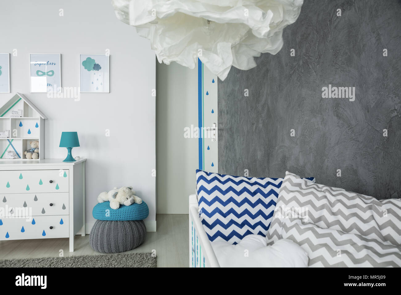 Child room with concrete wall, cot and white dresser Stock Photo - Alamy
