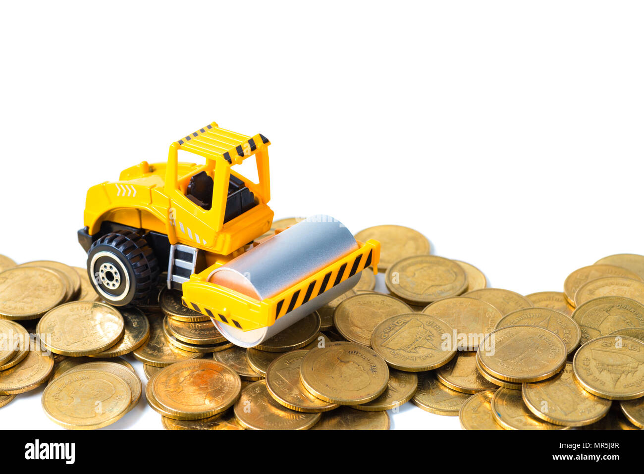 Mini Road roller machine with pile of gold coin, isolated on white ...
