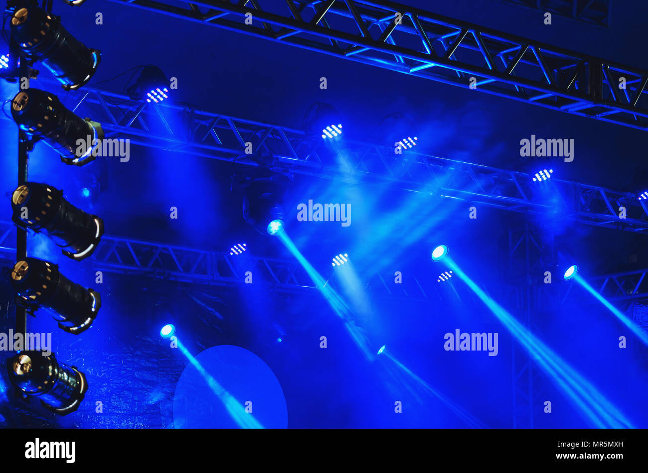 Blue spotlights of a stage with light cannons, led lights, steel ...