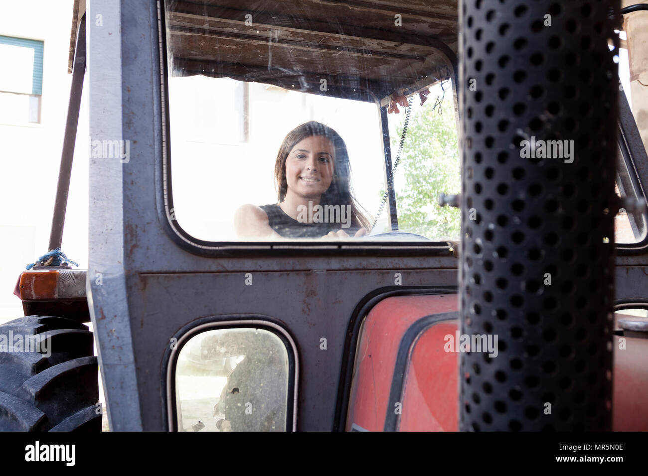 beautiful young woman sitting on a tractor Stock Photo - Alamy
