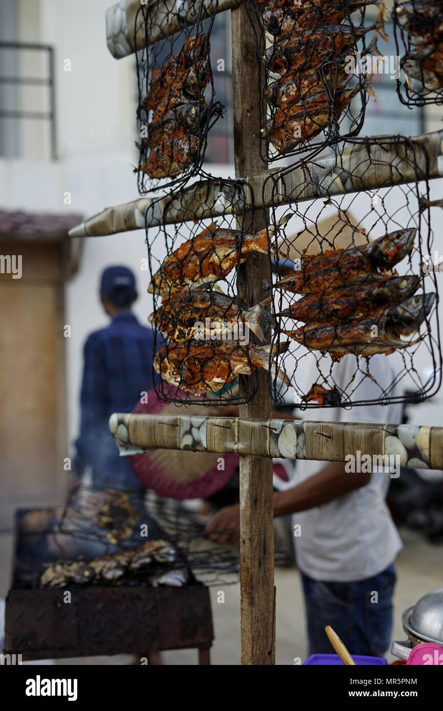 Food vendor cooks and sells Barbecue Grill fish at the street market in ...