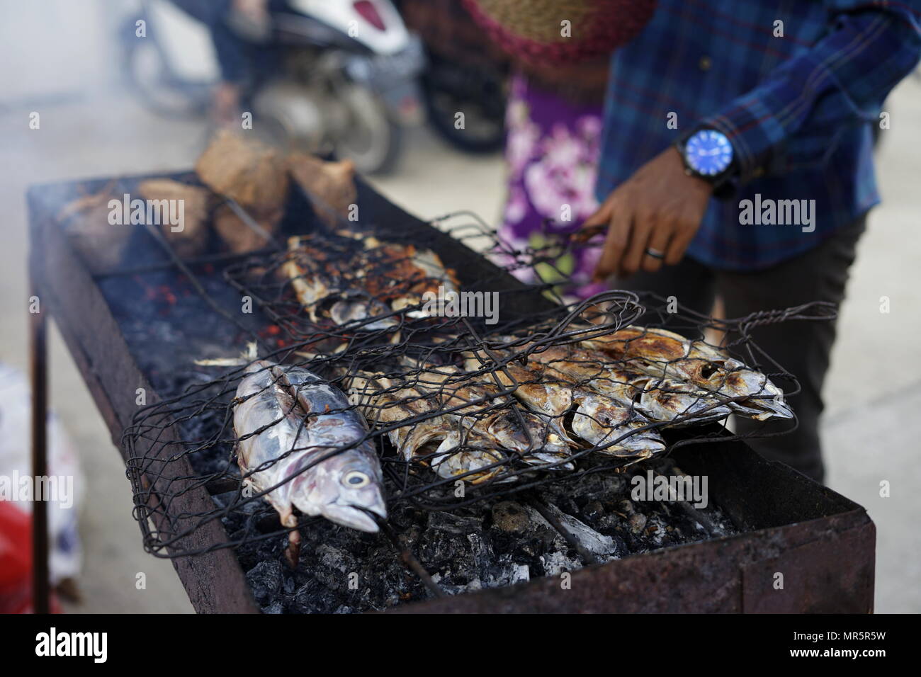 Food vendor cooks and sells Barbecue Grill fish at the street market in ...