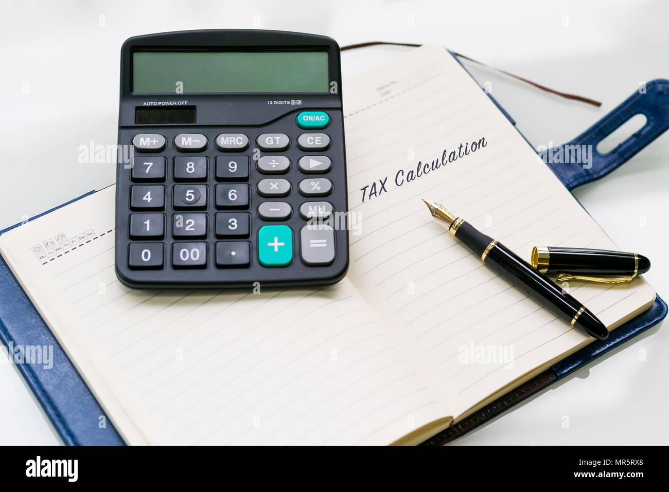 pen, calculator and notebook with TAX Calculation word on the white ...