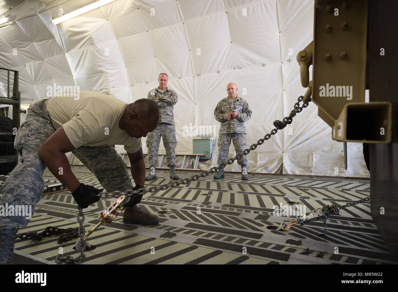 U.S. Air Force Master Sgt. Waymon Sparrow tightens the cargo hold ...