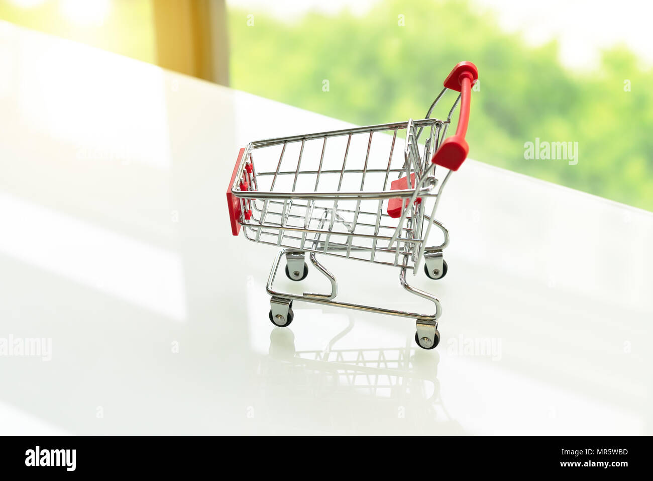 Empty shopping cart trolley on white table with green backgrounds Stock ...