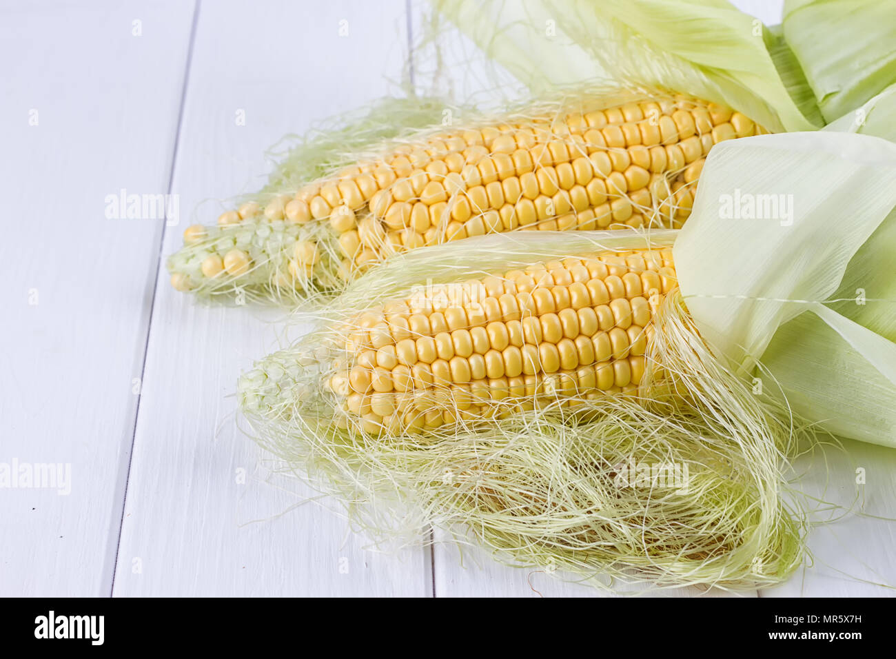 fresh corns on the wooden white background Stock Photo - Alamy